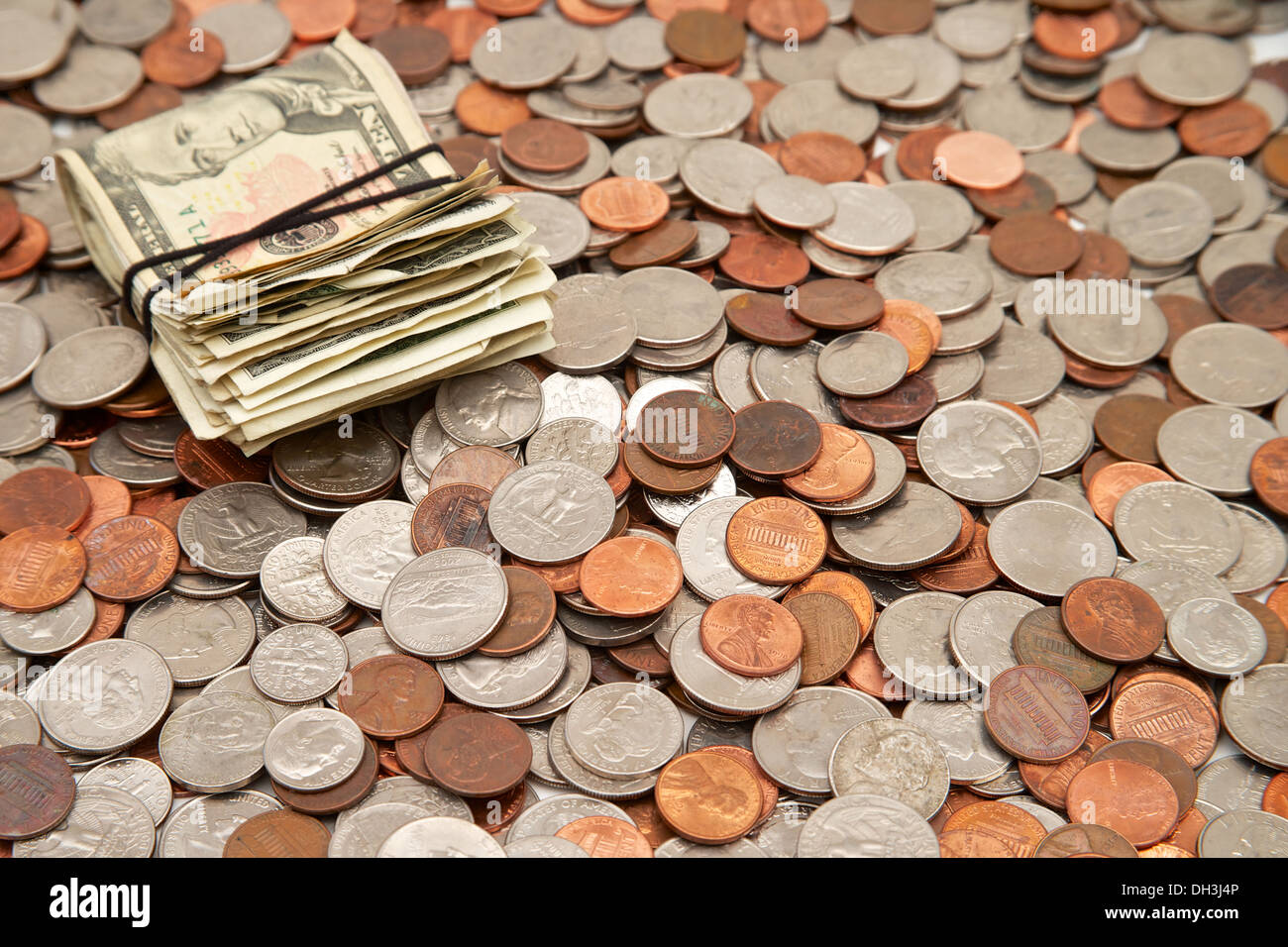 Folded and rubber banded stack of money laying on top of a pile of ...