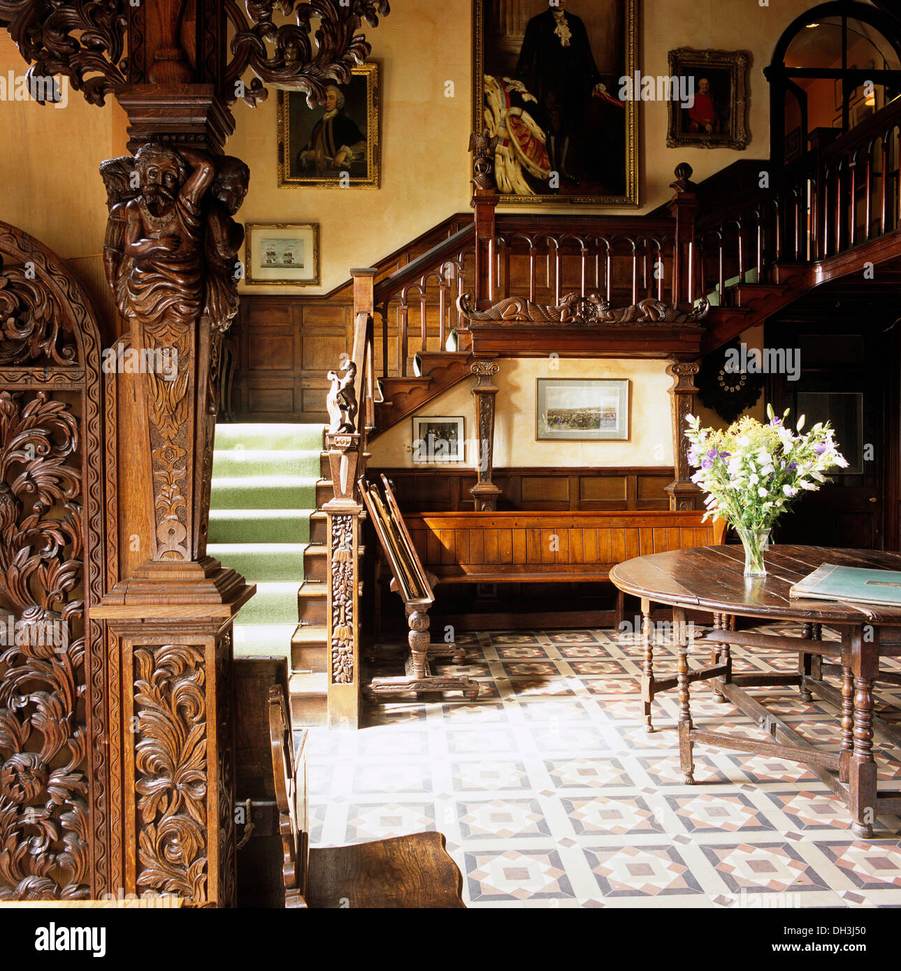 Large country hall with heavily carved oak wooden staircase and ...