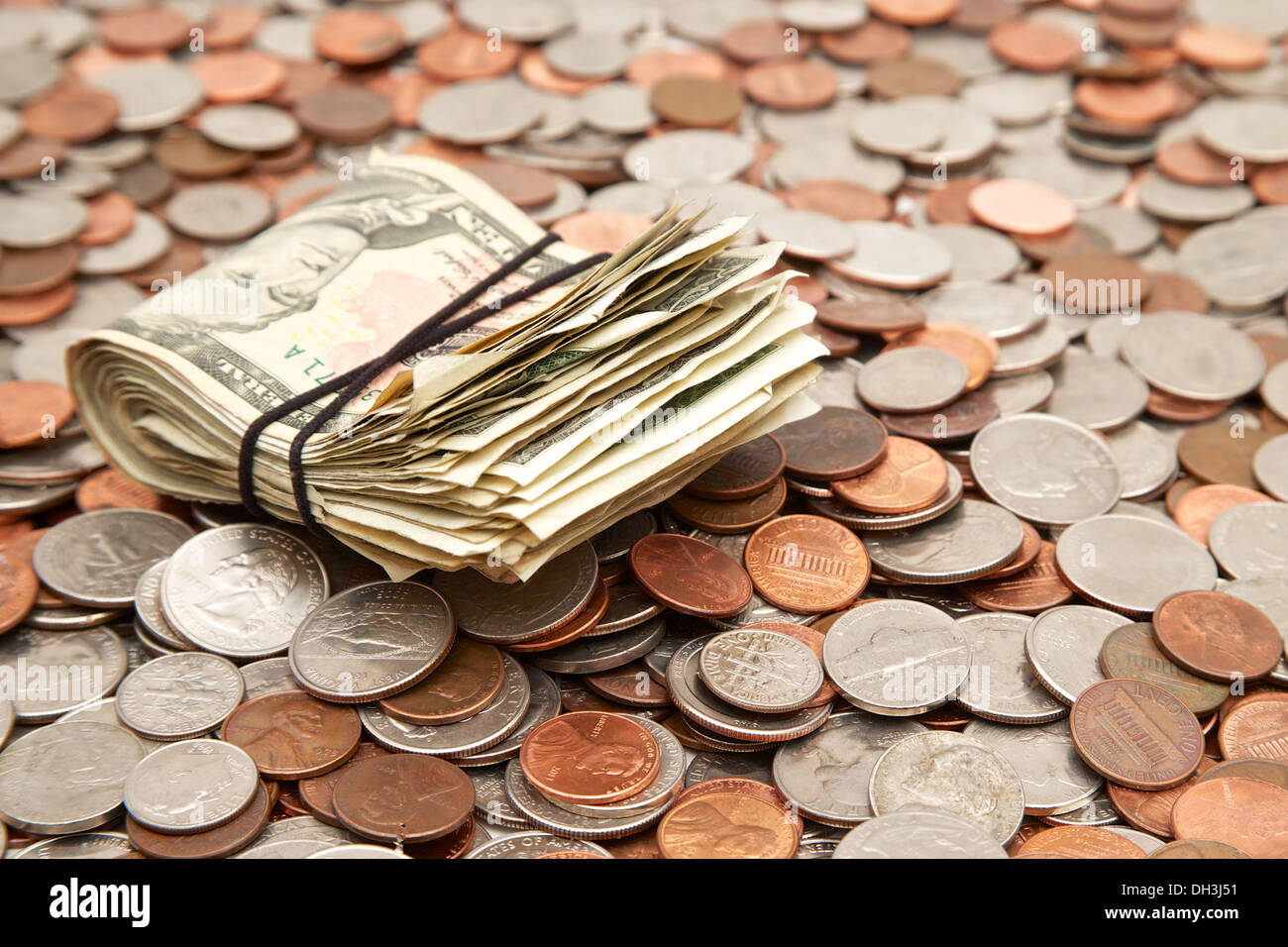 Folded and rubber banded stack of money laying on top of a pile of ...