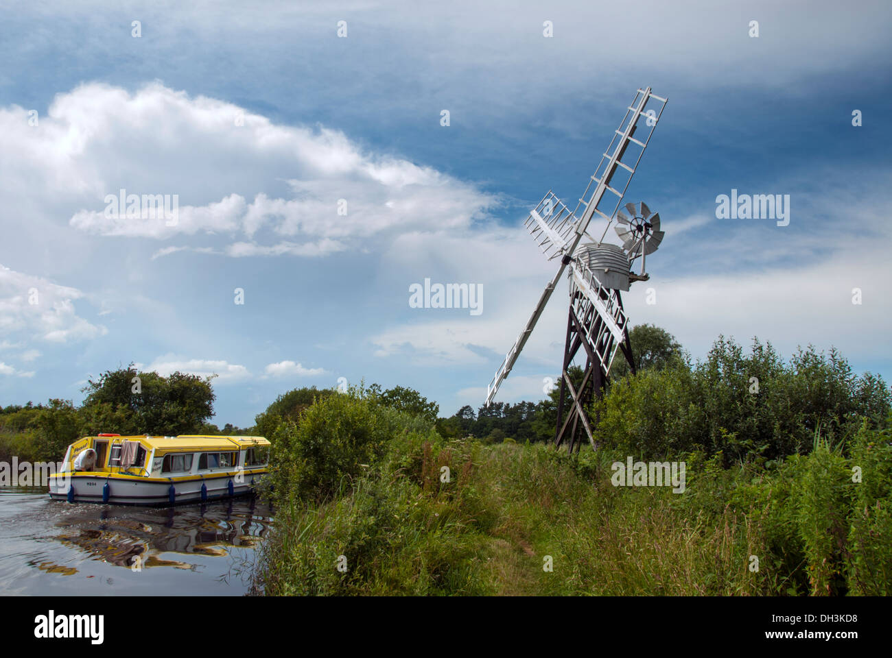 View of the Norfolk broads with skeleton windmill and pleasure craft ...