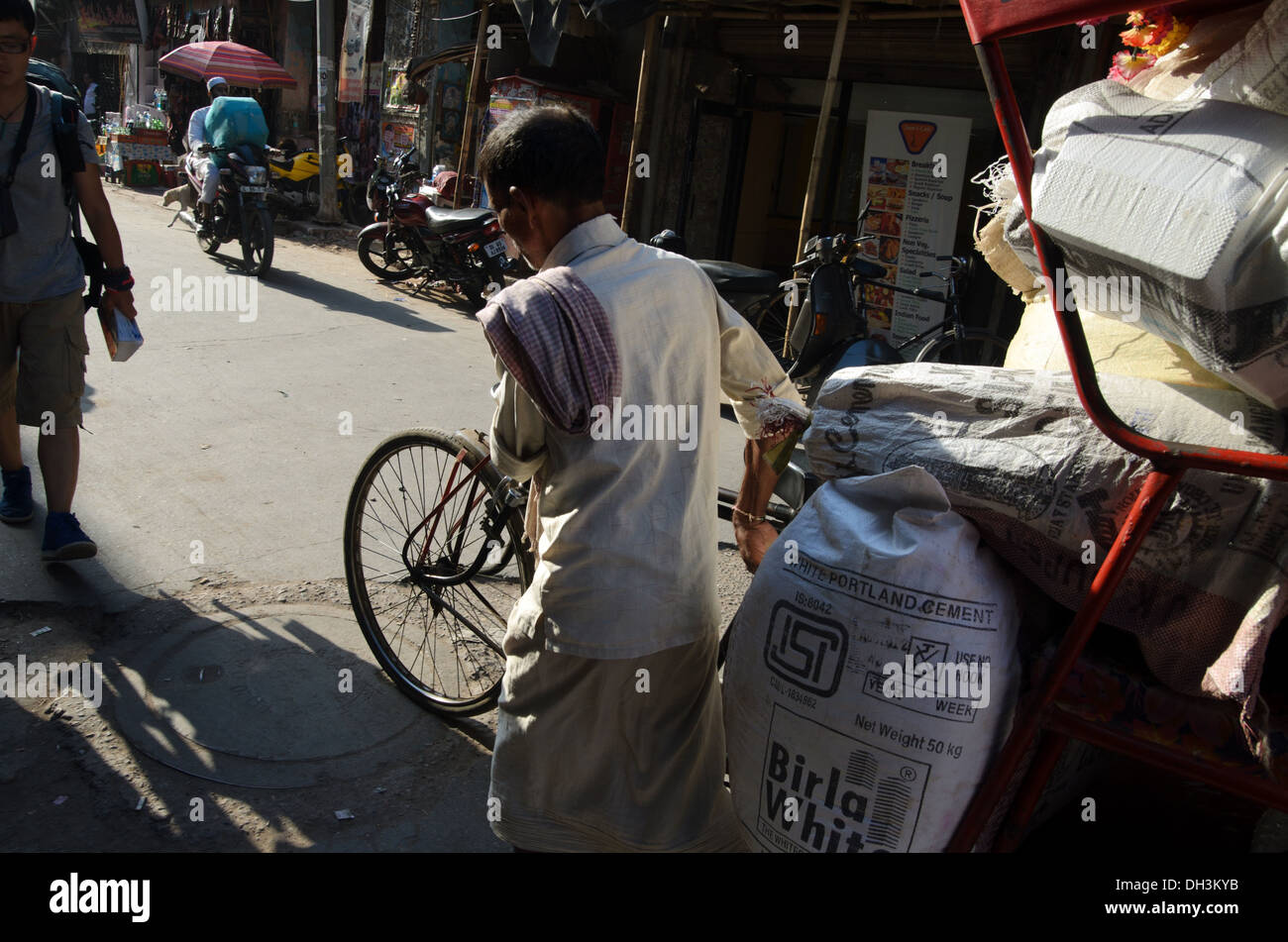 Cycle-rickshaw driver pulling his heavily loaded rickshaw, Main Bazaar ...