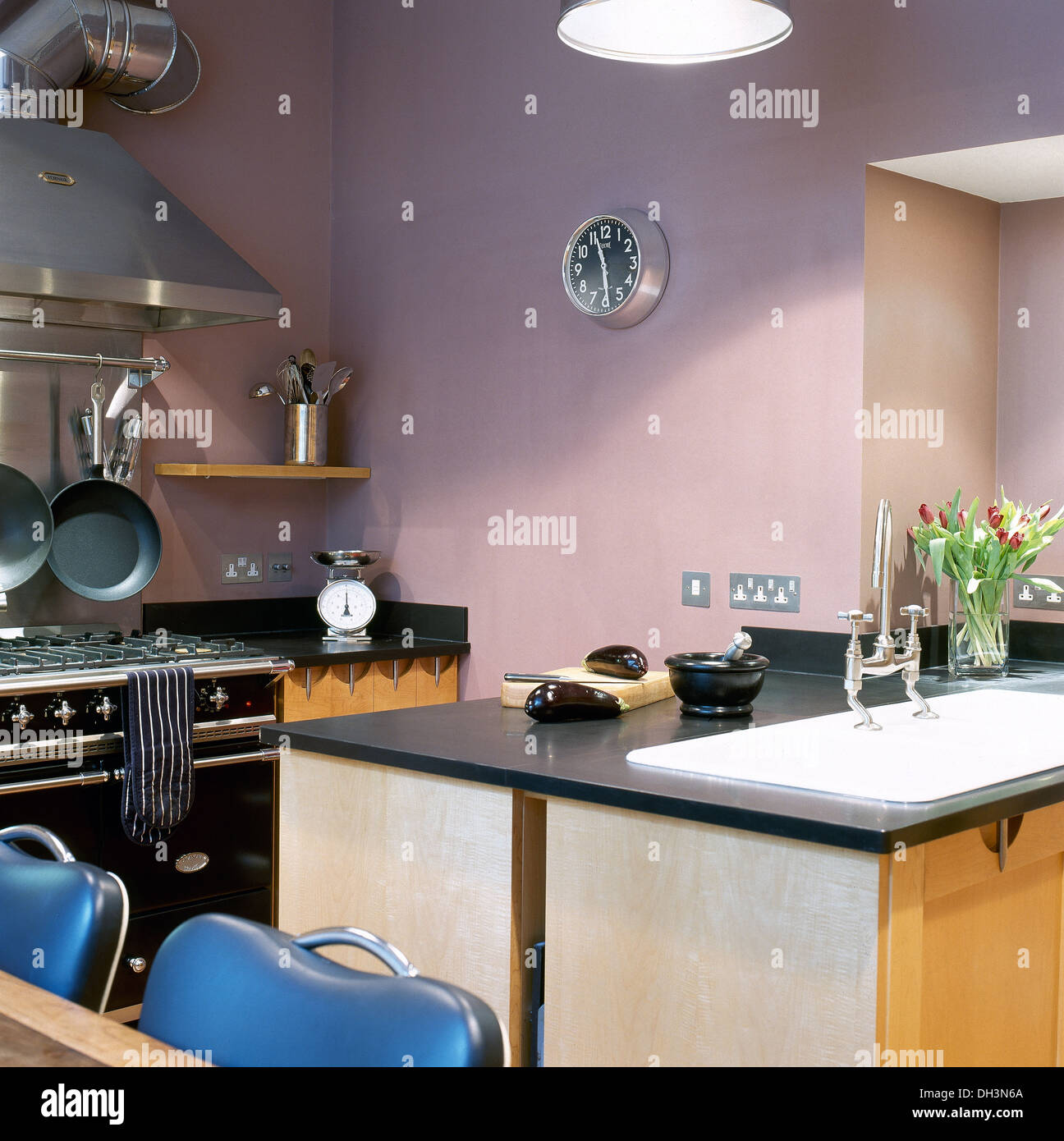 Black granite topped island unit in modern mauve kitchen with blue and ...