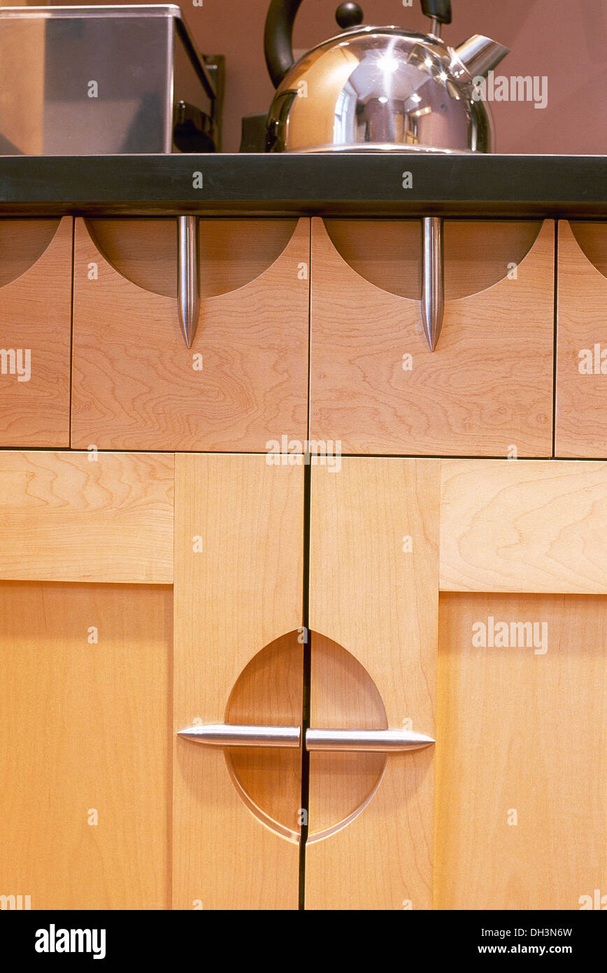 Close-up of stainless steel kettle on worktop above pale wood fitted ...