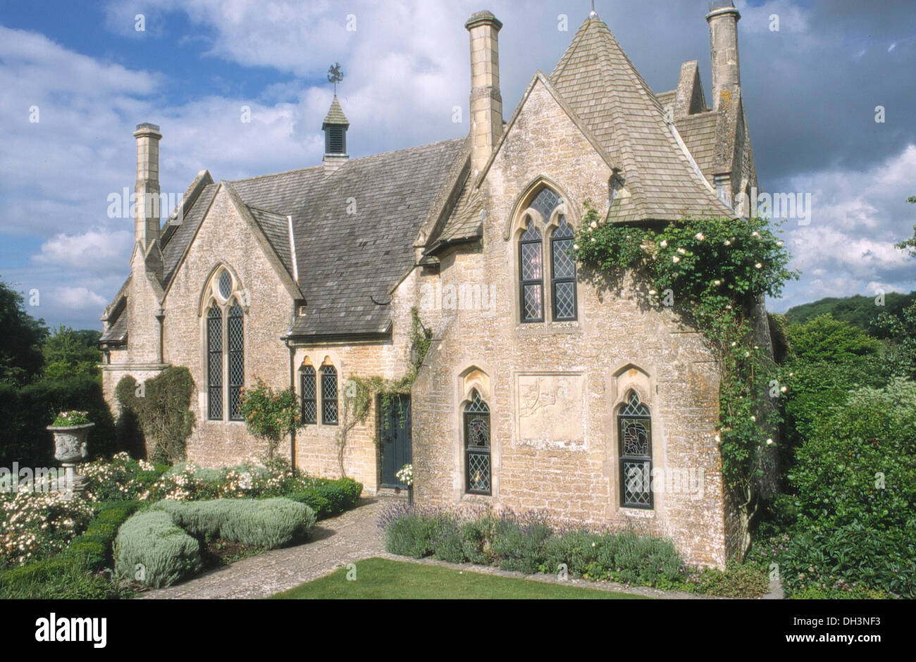 Stone path and lavender hedge in formal garden in front of converted ...