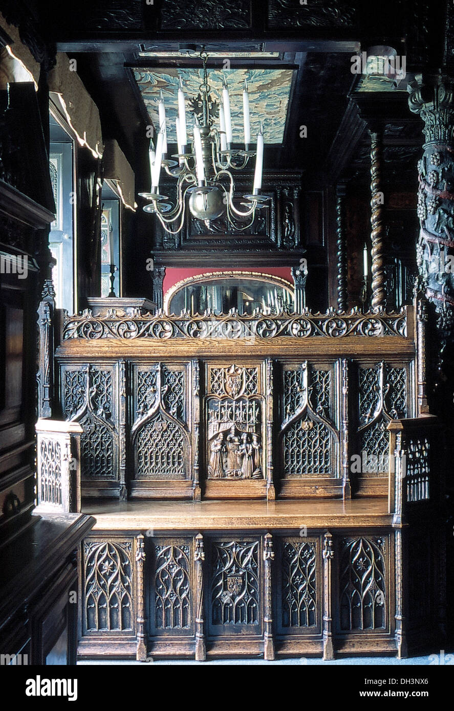 Ornately carved wooden Gothic screen in country bedroom with brass ...
