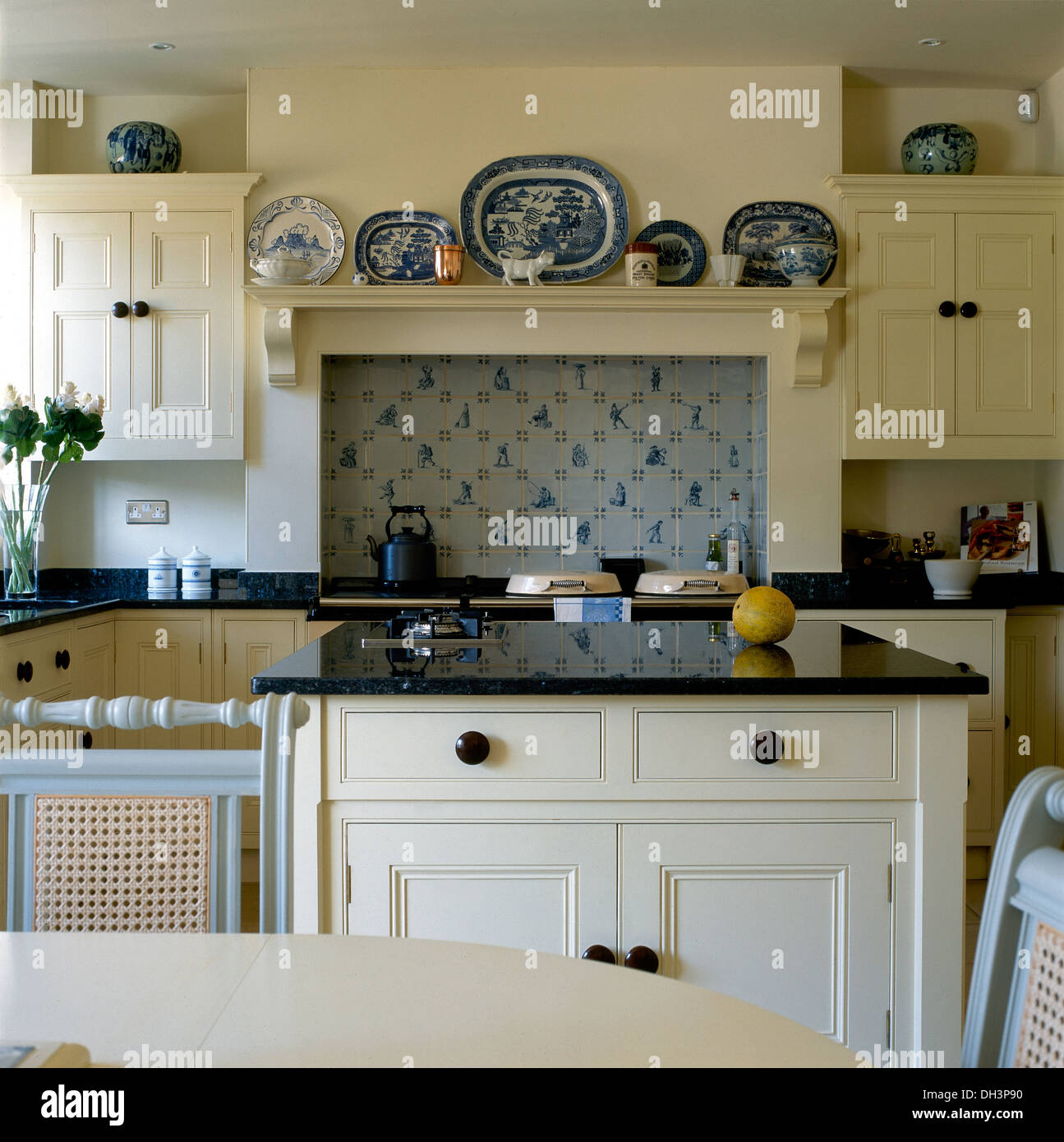Granite topped island unit in cottage kitchen with collection of blue ...