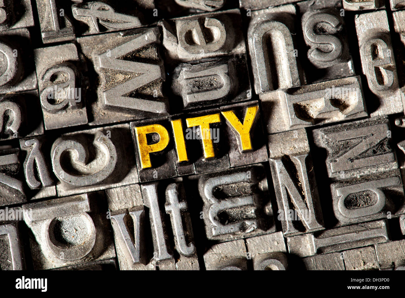 Old lead letters forming the word PITY Stock Photo - Alamy