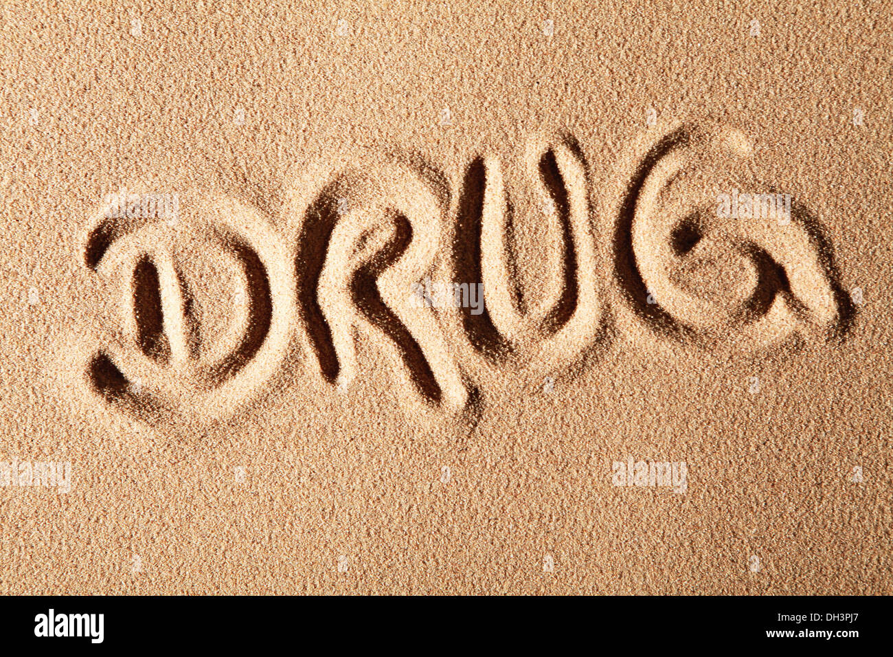 The word DRUG, drawn in sand Stock Photo - Alamy