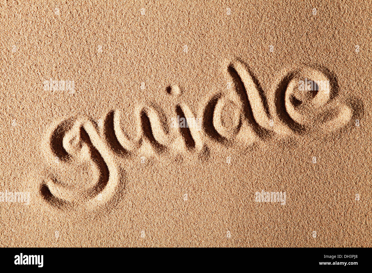 The word guide, written in sand Stock Photo - Alamy