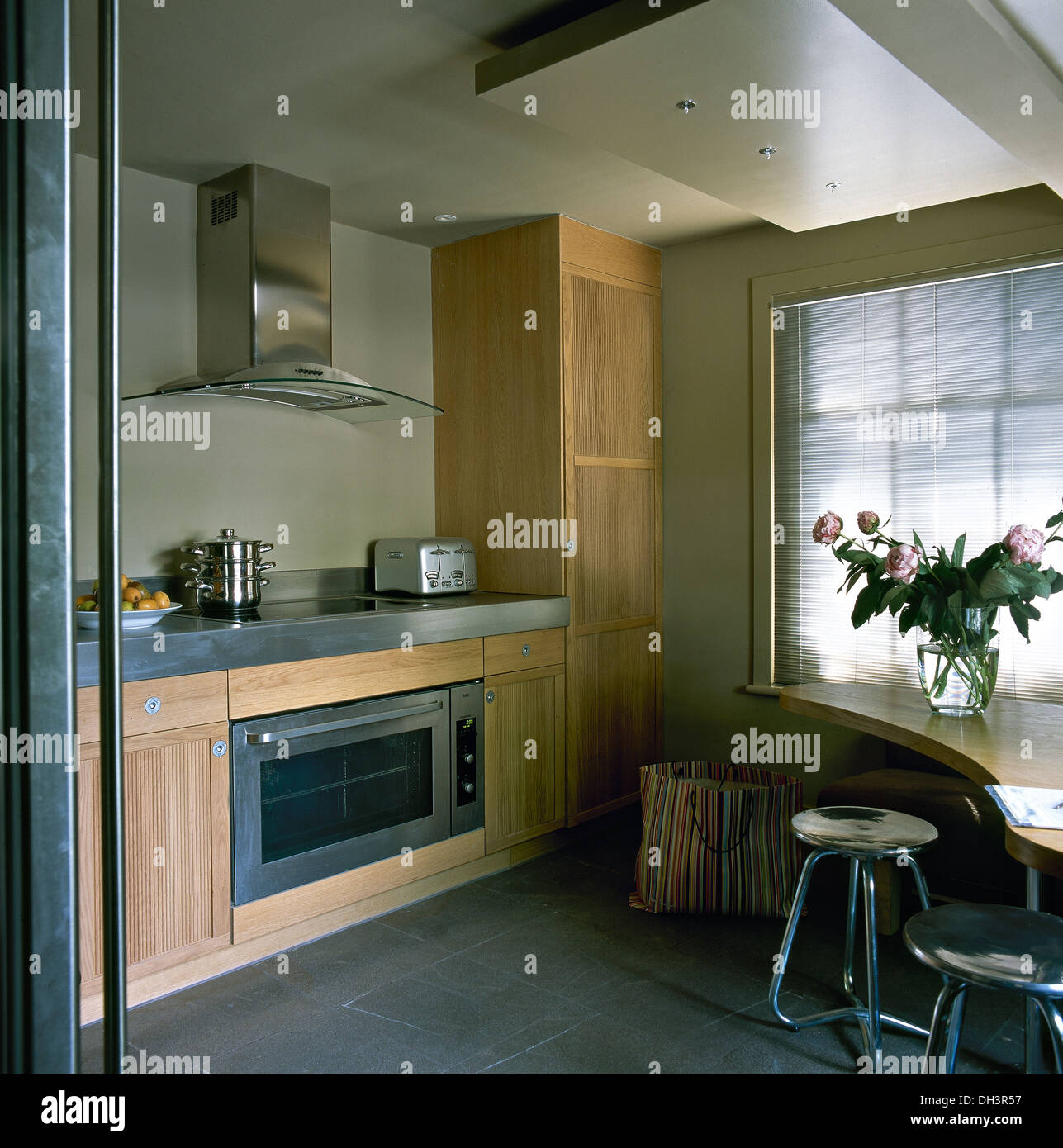 Chrome extractor above hob and oven in fitted unit with stainless steel ...