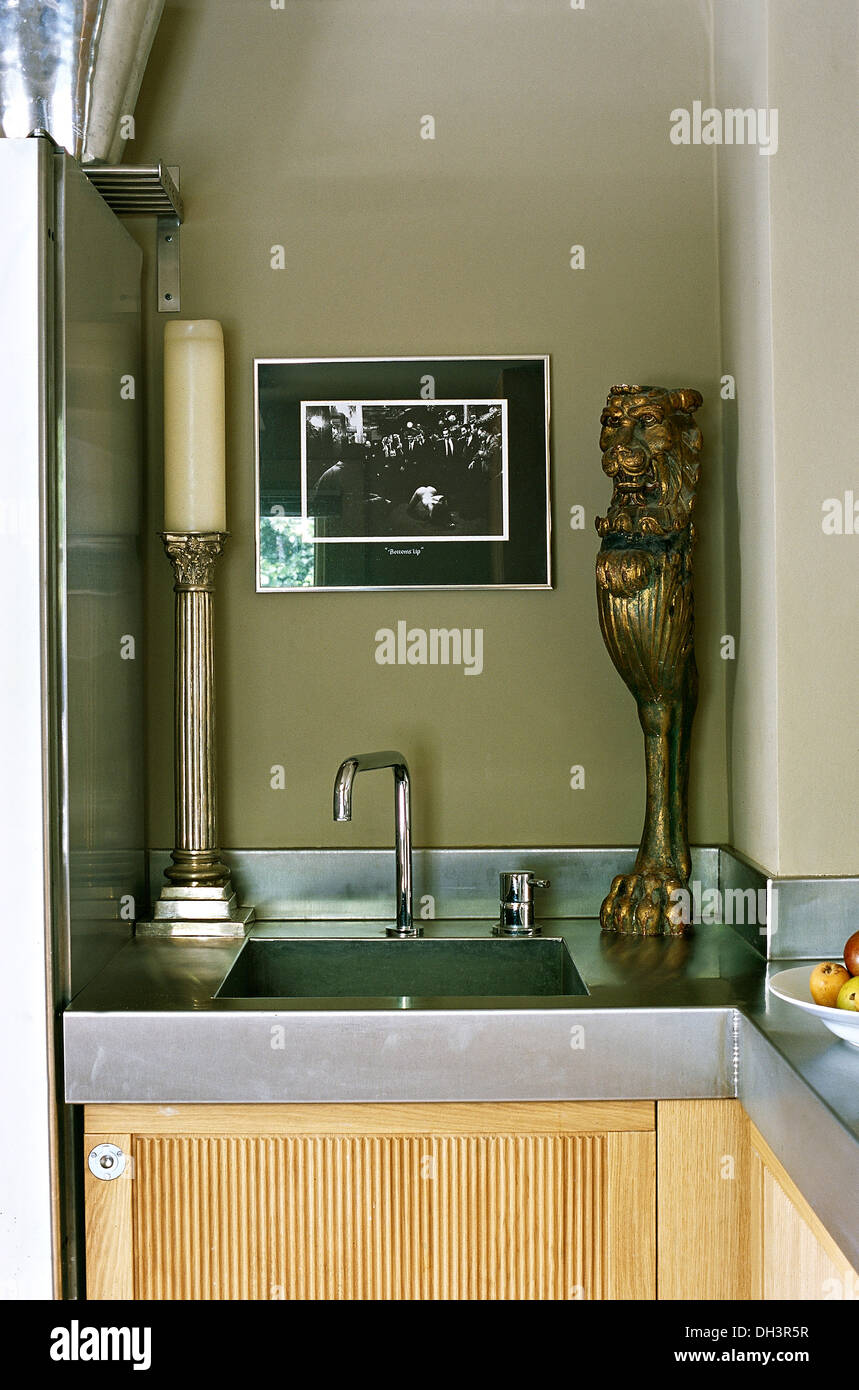 Chrome tap above sink set in stainless steel work top with large silver ...