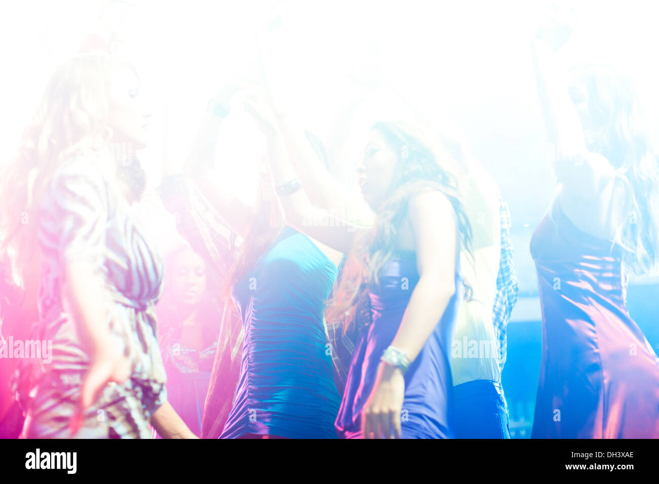 Group of party people - men and women - dancing in a disco club to the ...