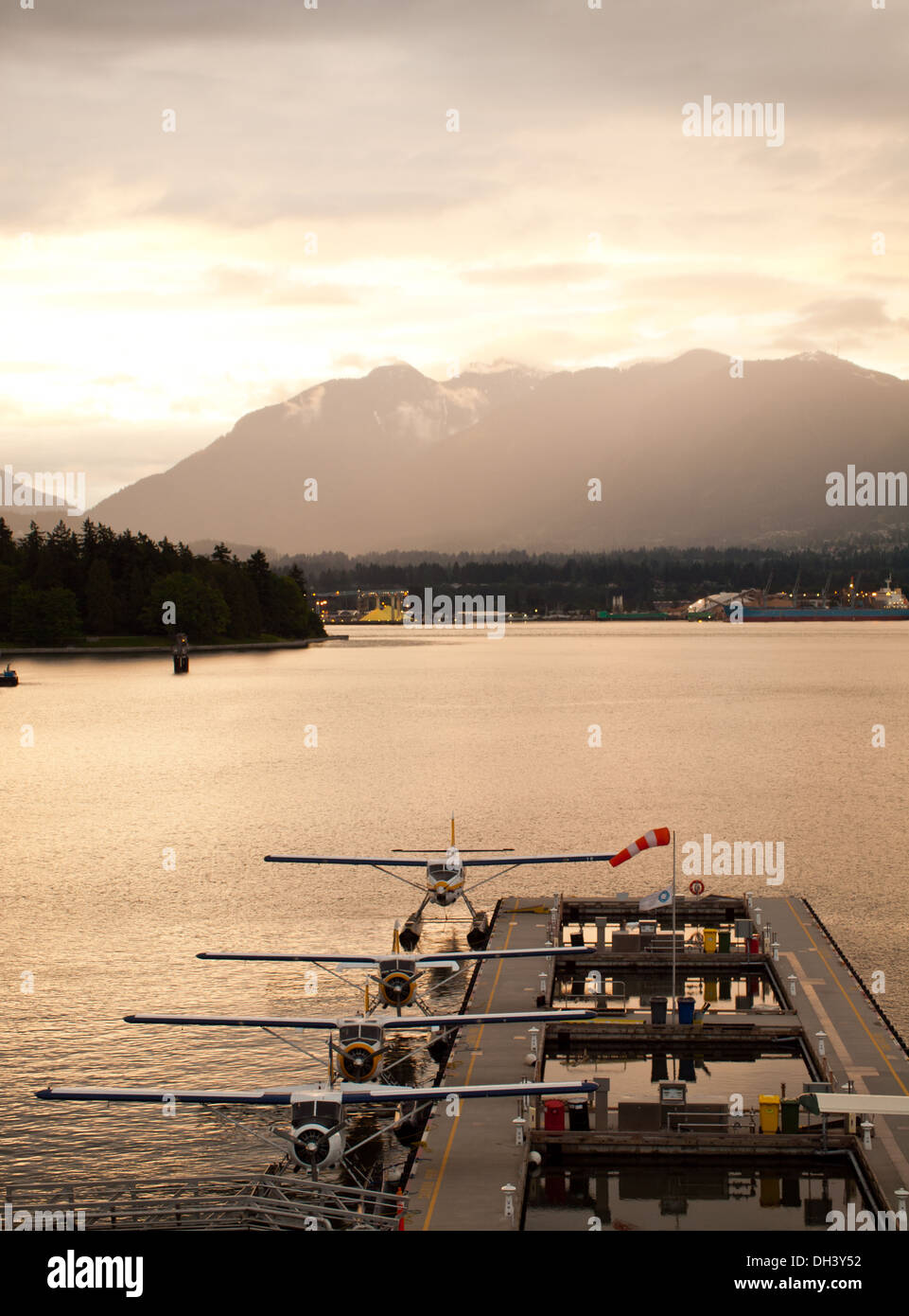 At sunset, four seaplanes (float planes) docked at the Vancouver ...