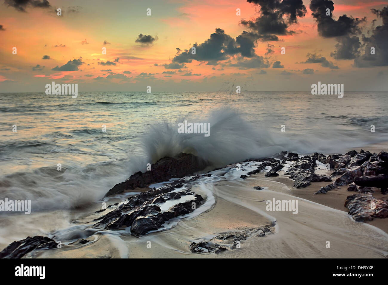 Sea waves lash line impact rock on the beach Stock Photo - Alamy