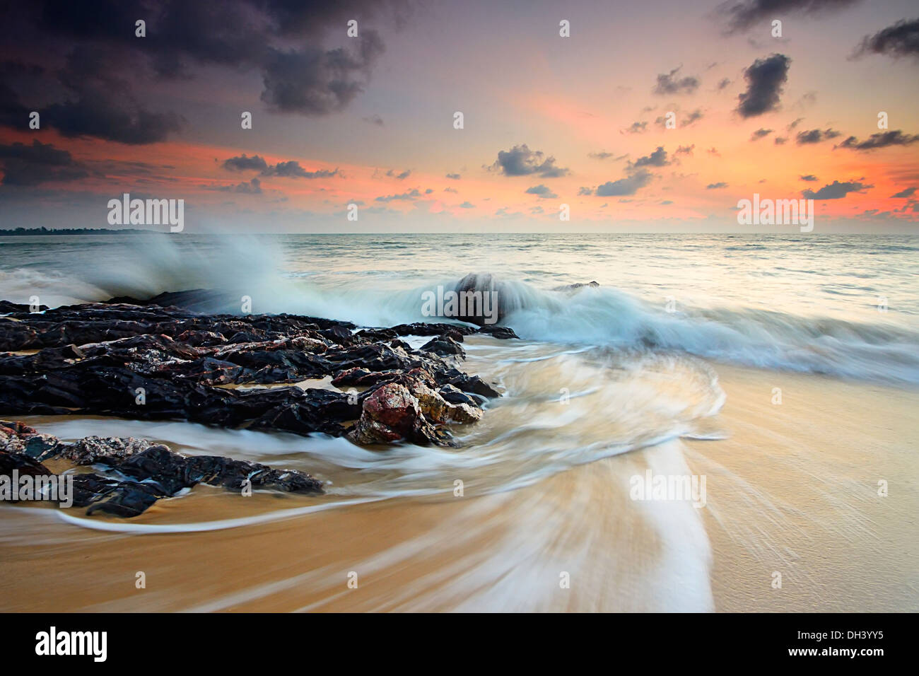 Sea waves lash line impact rock on the beach Stock Photo - Alamy