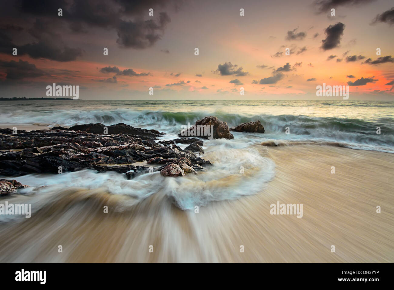 Sea waves lash line impact rock on the beach Stock Photo - Alamy