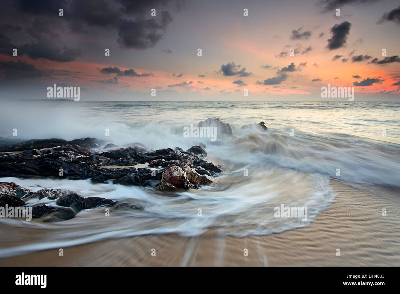 Sea waves lash line impact rock on the beach Stock Photo - Alamy