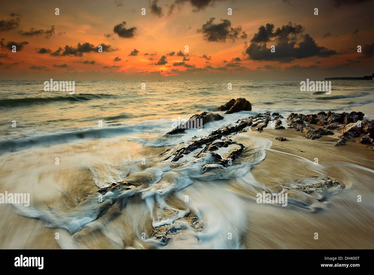 Sea waves lash line impact rock on the beach Stock Photo - Alamy