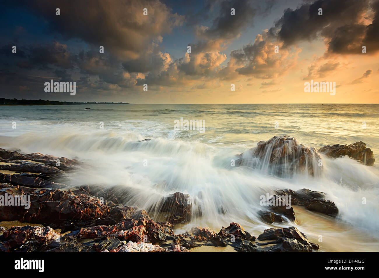 Sea waves lash line impact rock on the beach Stock Photo - Alamy