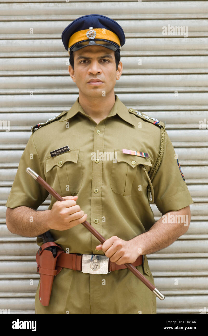 Portrait of a policeman holding a nightstick Stock Photo - Alamy