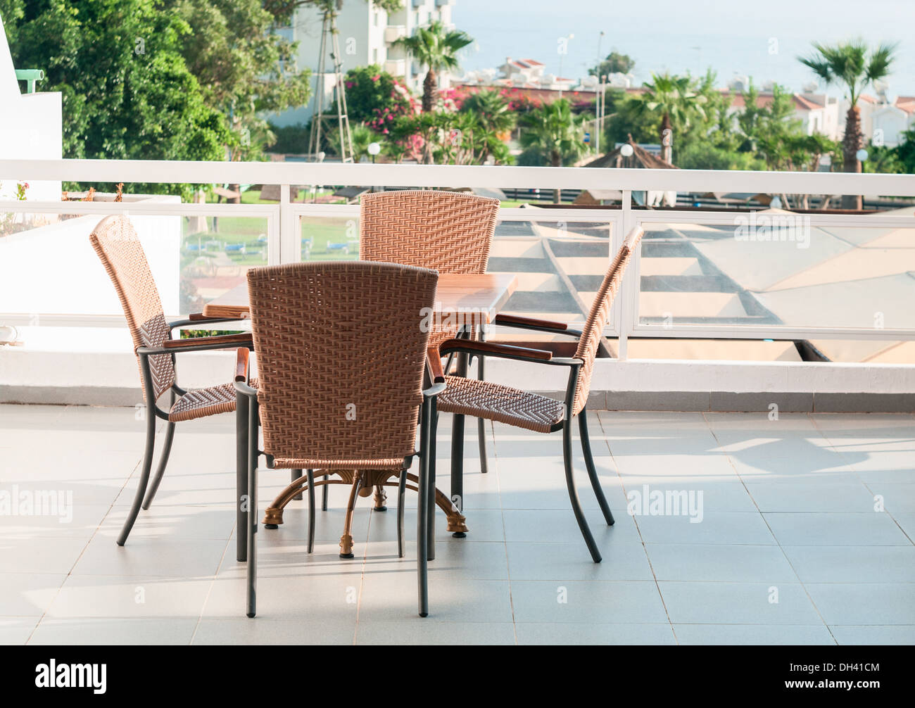 Table with four chairs standing on open air terrace Stock Photo - Alamy