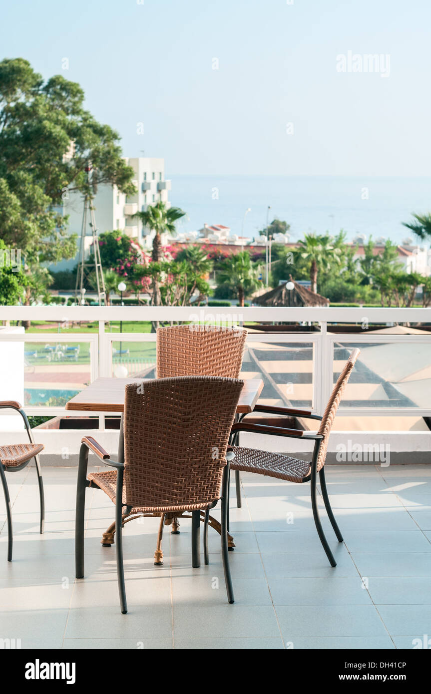 Table with chairs standing on open air terrace Stock Photo - Alamy