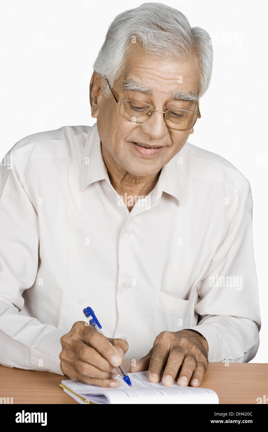 Senior man writing on a notepad Stock Photo - Alamy