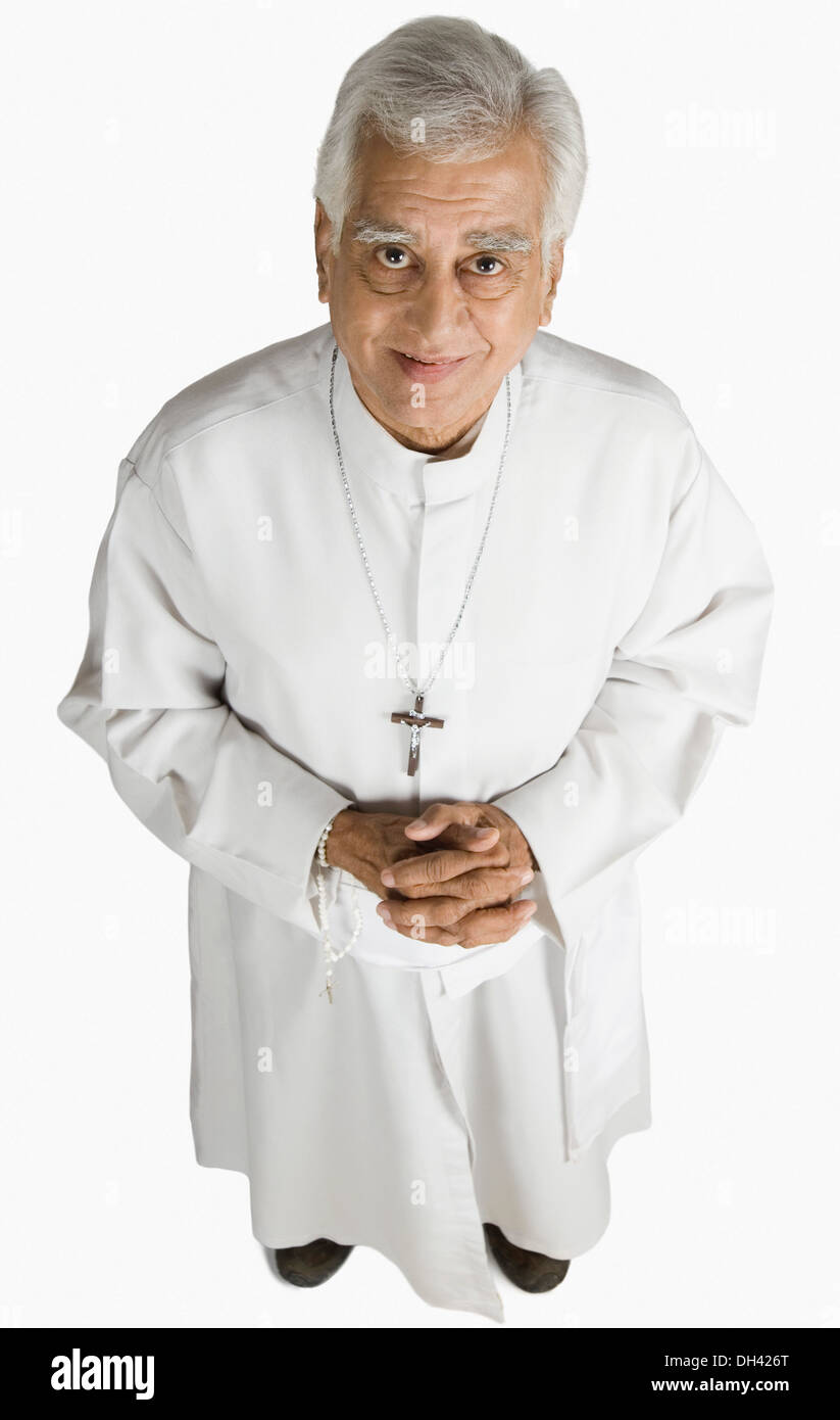 Portrait of a priest standing with hands clasped and smiling Stock ...