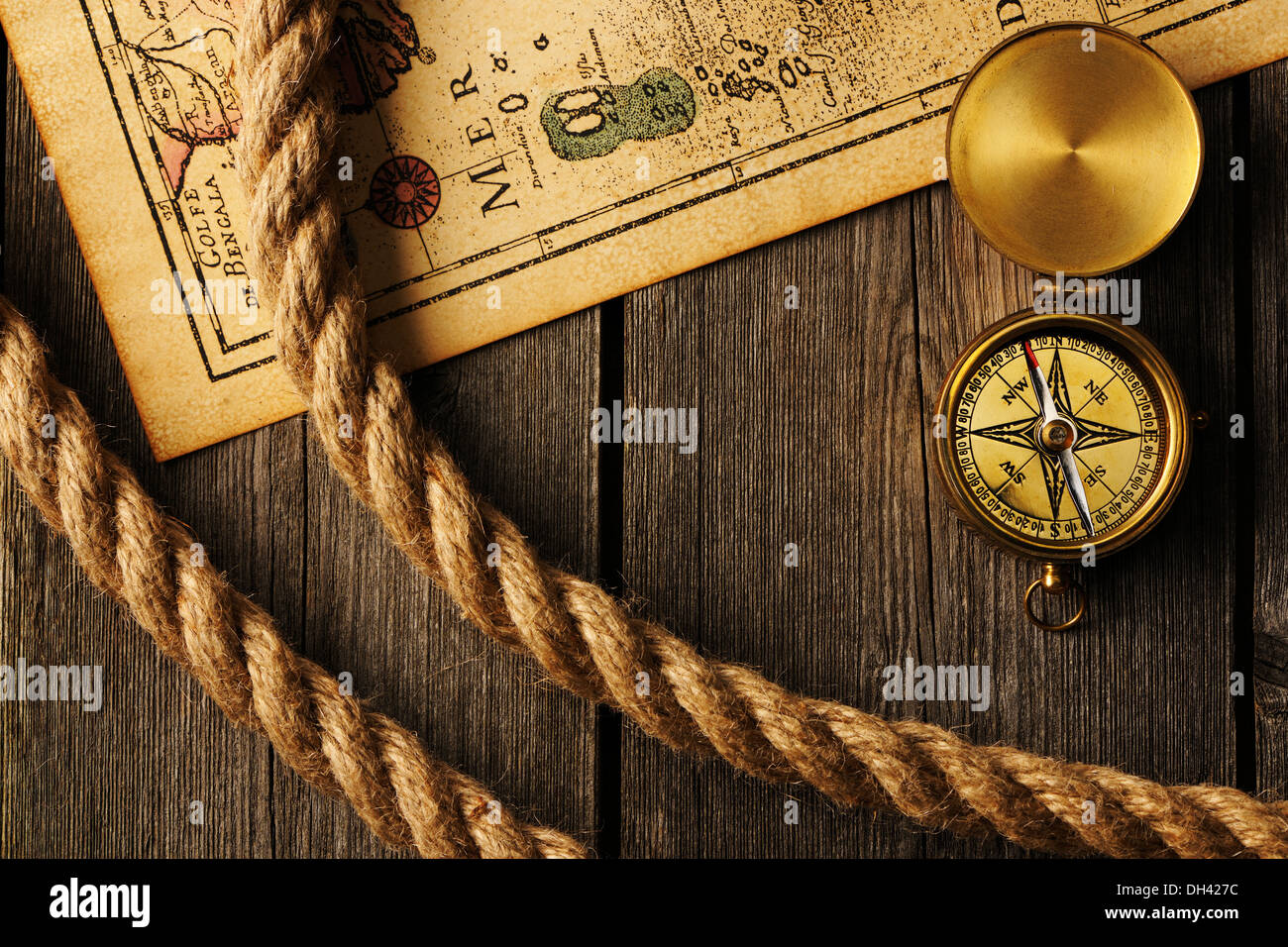 Antique compass and rope over old map Stock Photo - Alamy