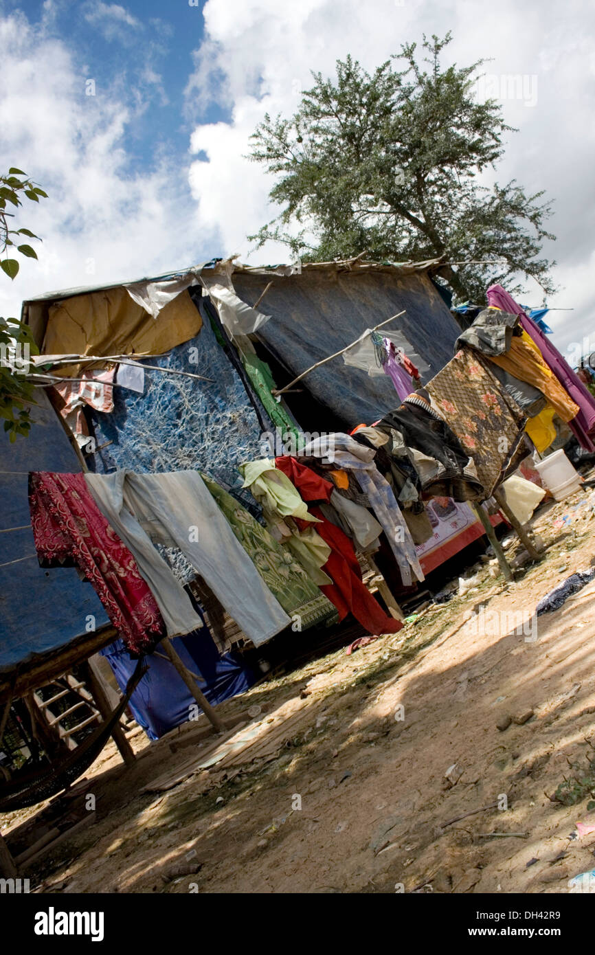 Laundry is drying near plastic and wood homes in a neighborhood near a ...