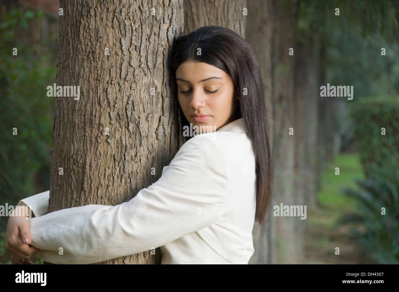 Side profile of a businesswoman hugging a tree Stock Photo - Alamy