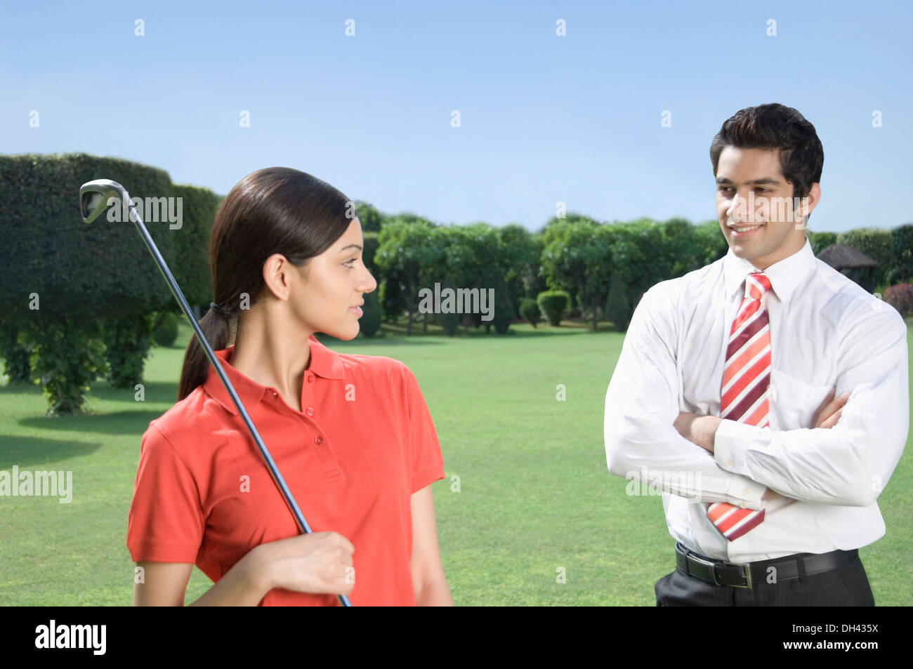 Couple standing in a golf course Stock Photo - Alamy