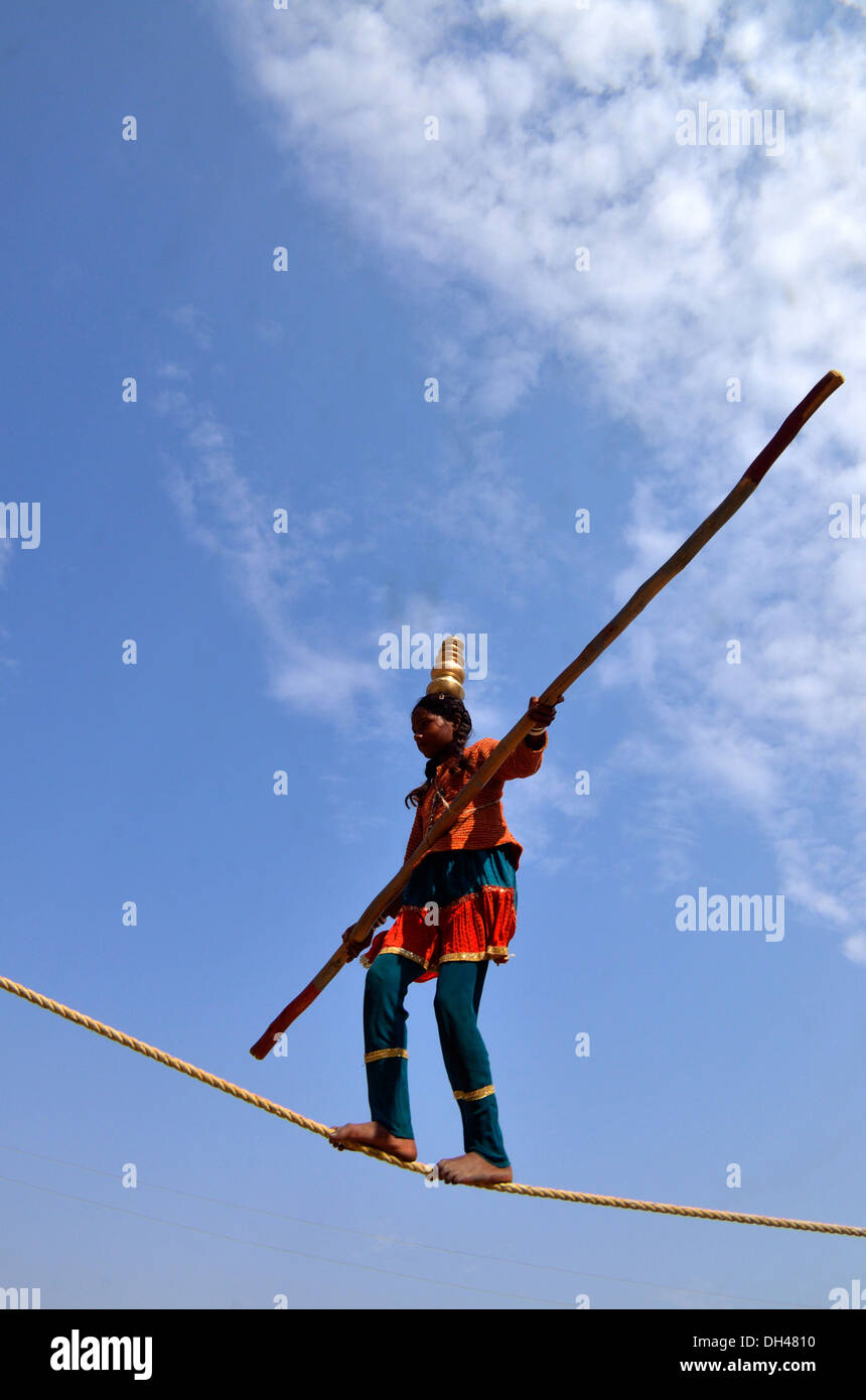 Young girl walking performing on rope acrobat trapeze Rajasthan India ...