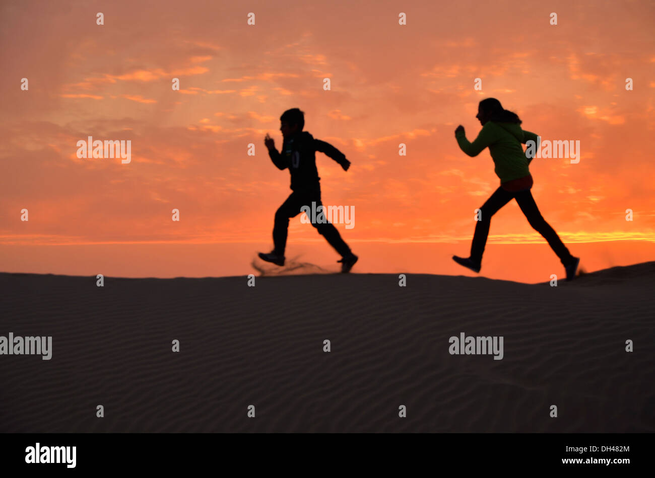 Boy and girl running on sand hi-res stock photography and images - Alamy
