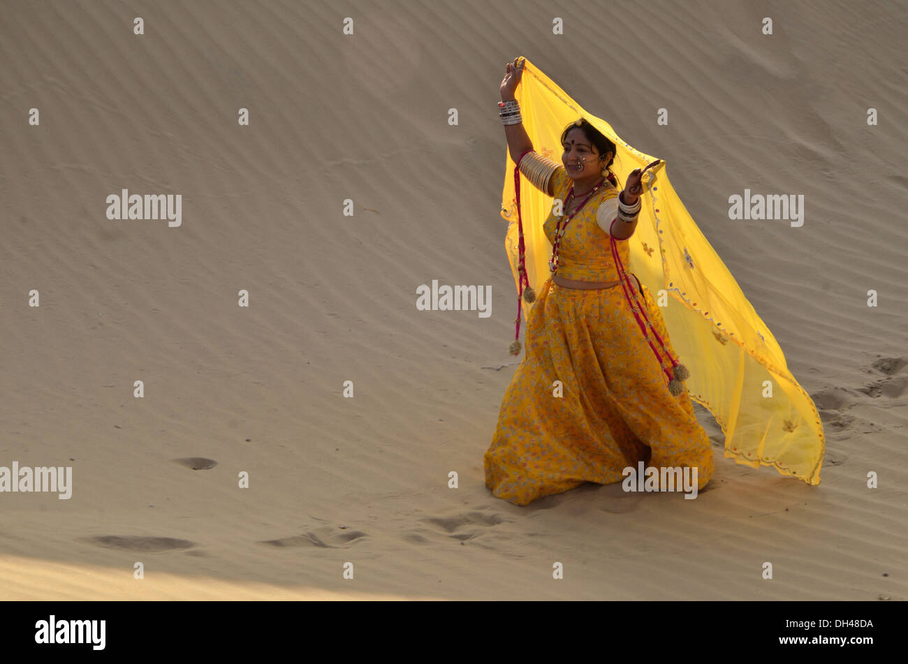Indian woman walking with flowing odhani on desert sand dune Rajasthan ...