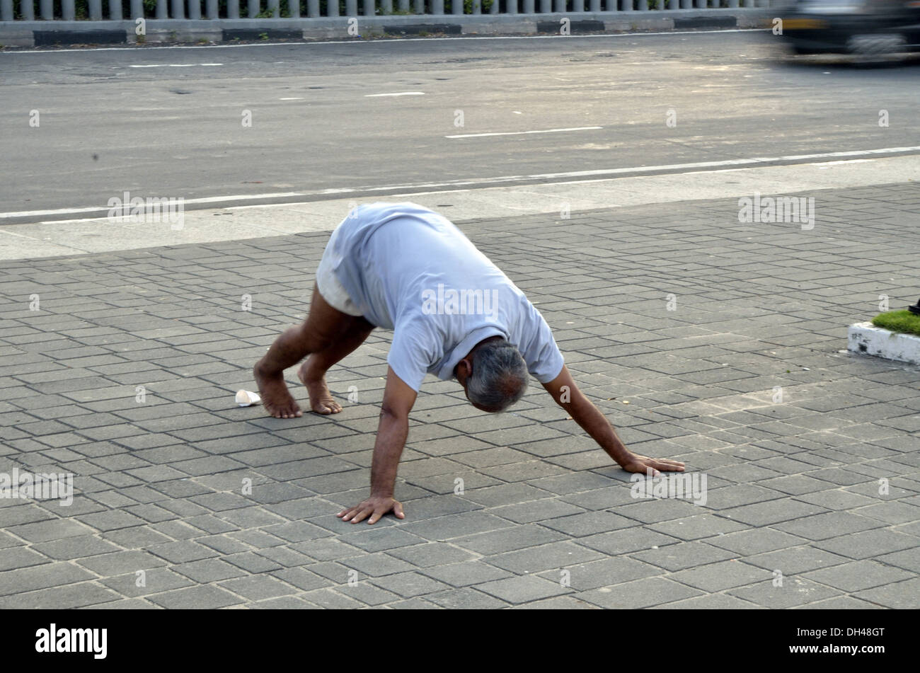 old man doing morning exercise on footpath marine drive Mumbai ...