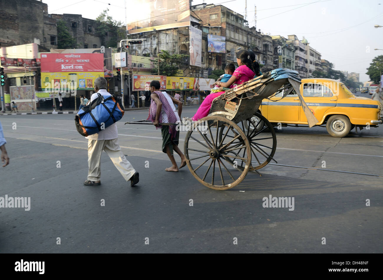 hand rickshaw puller pulling rickshaw with woman passenger on street of ...