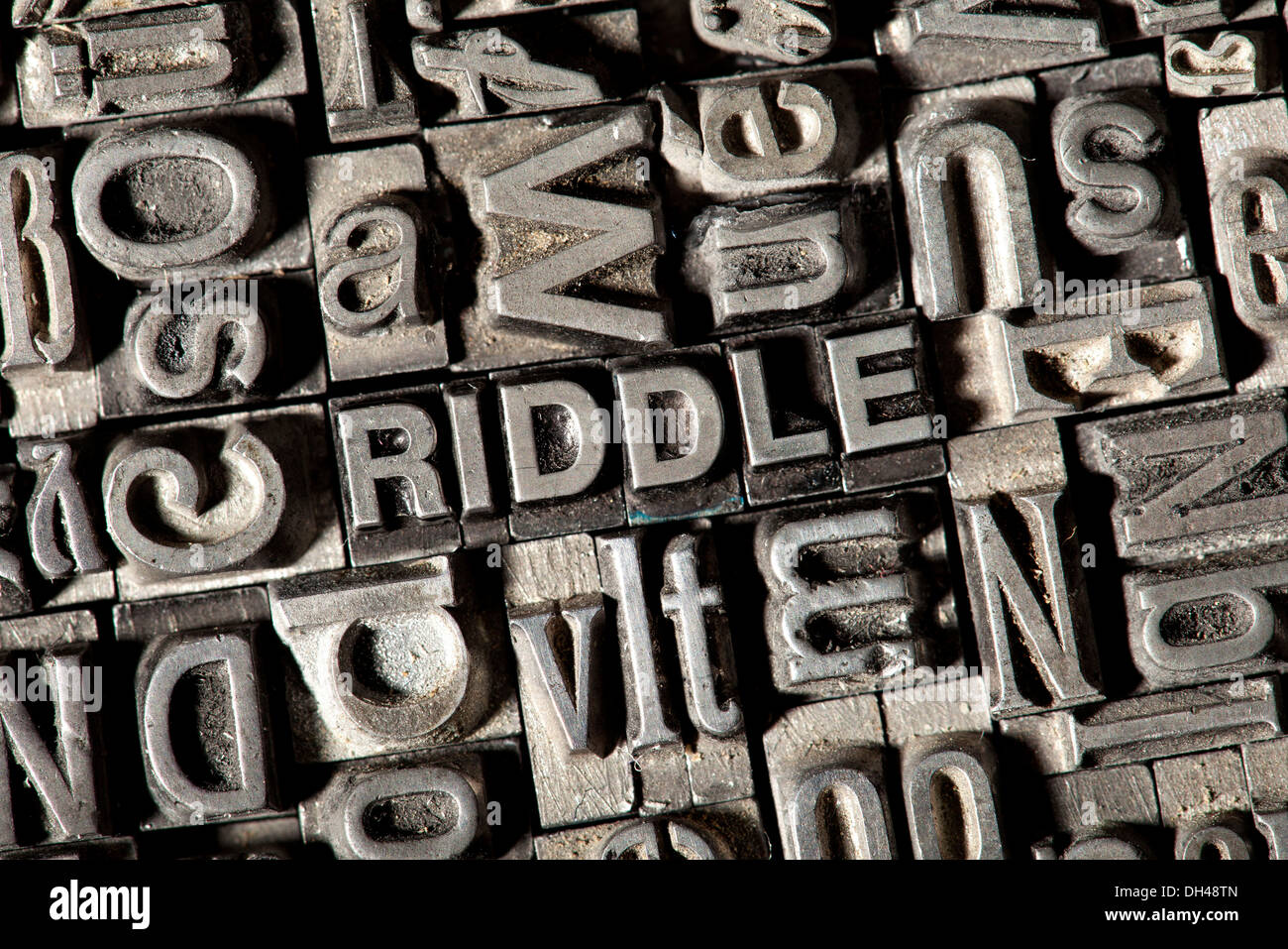 Old lead letters forming the word RIDDLE Stock Photo - Alamy