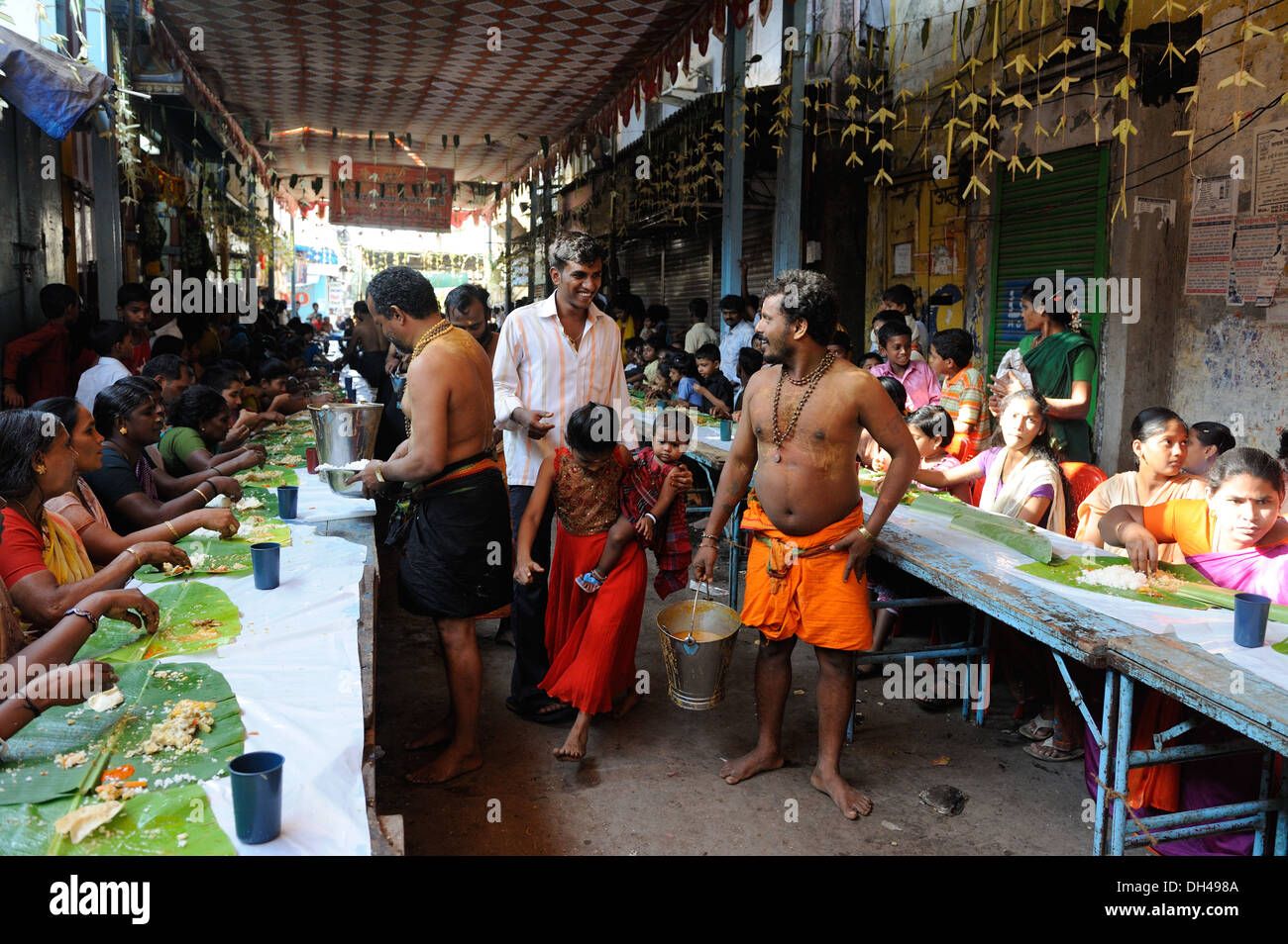 people eating food on banana leaves in slums of Dharavi Mumbai India ...