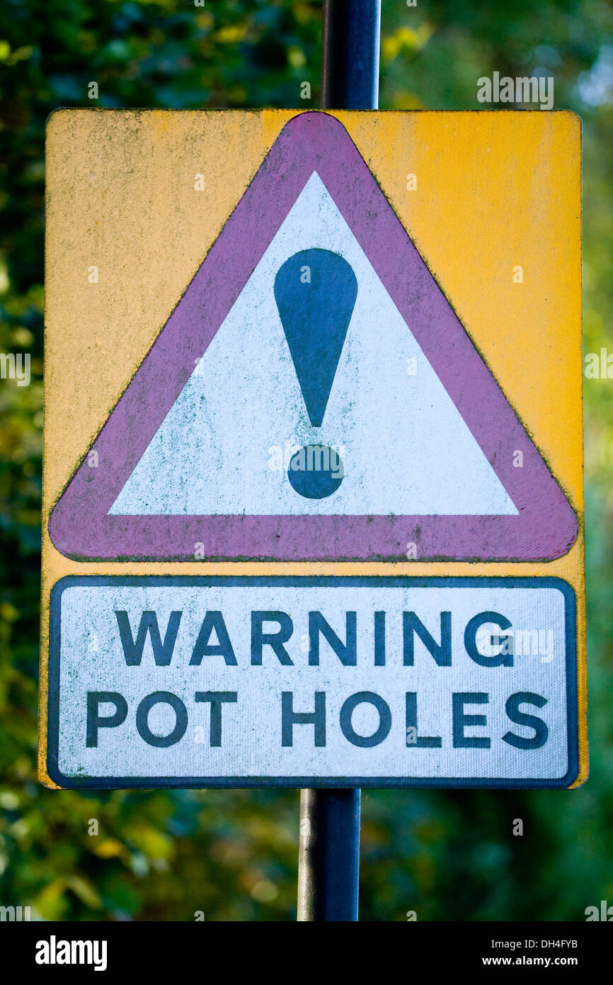 A red warning hazard triangle / triangular sign warning pot hole ...