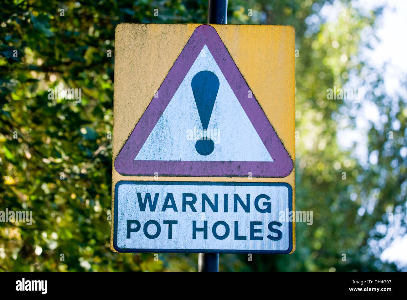A red warning hazard triangle / triangular sign warning pot hole ...
