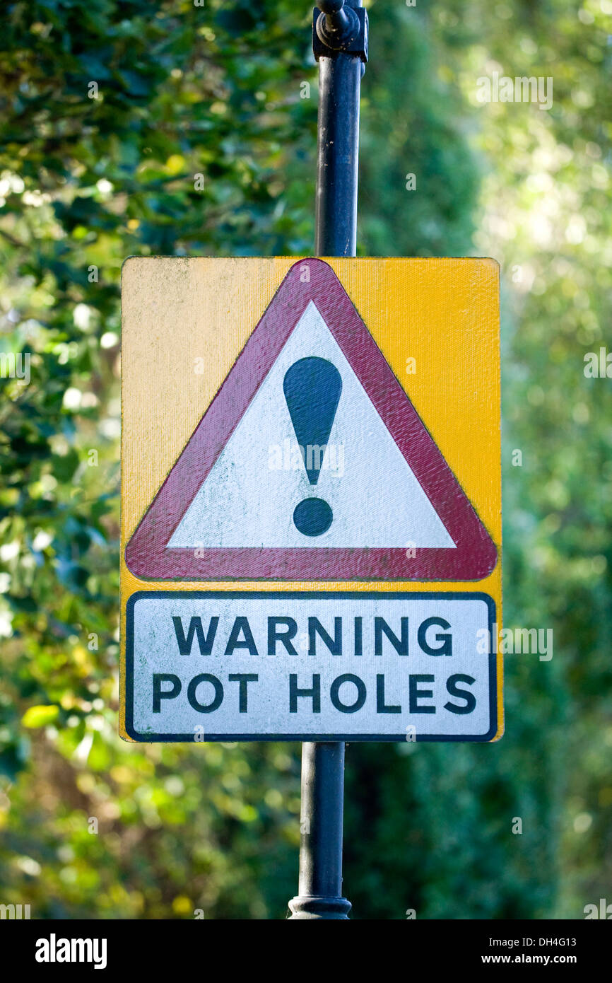 A red warning hazard triangle / triangular sign warning pot hole ...