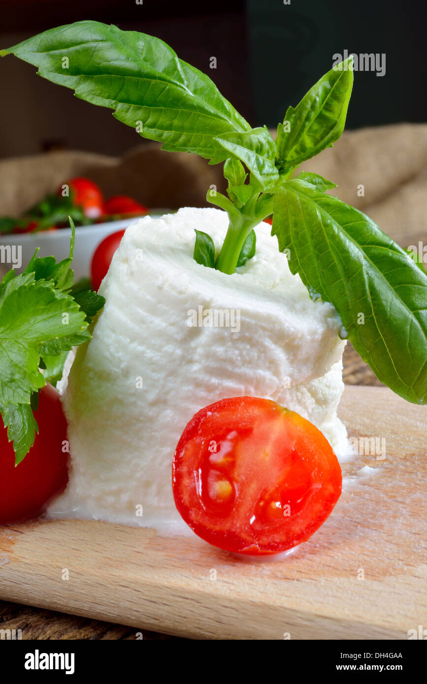 italian fresh cheese called ricotta with tomatoes and basil Stock Photo ...