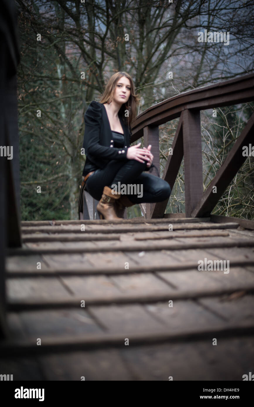 young woman crouch at bridge Stock Photo - Alamy