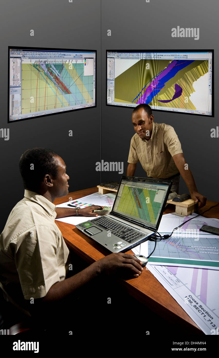 Exploration geologists discussing cross section showing stratigraphy of ...