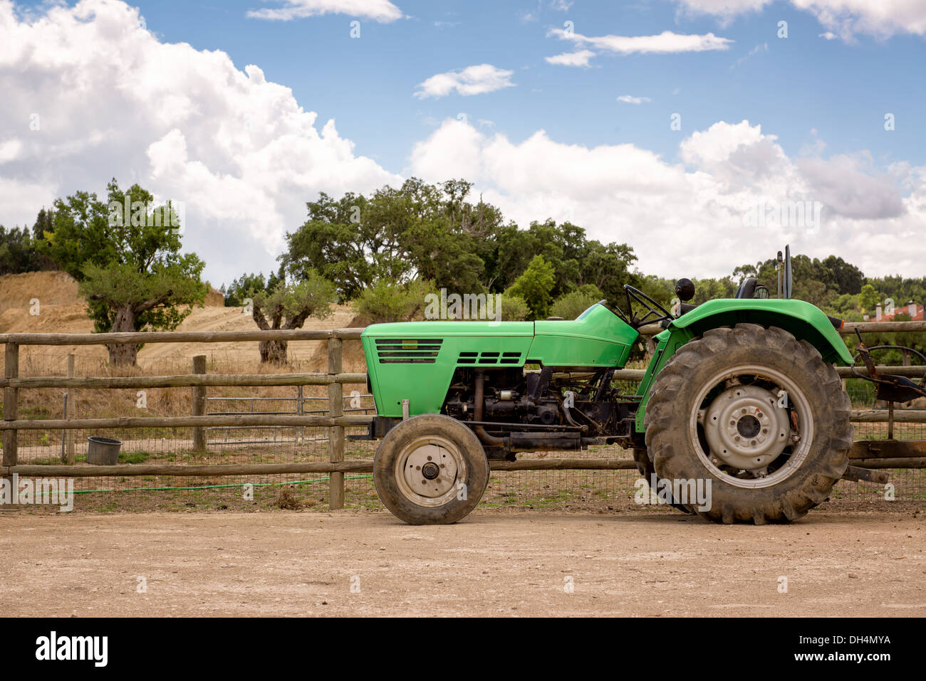 Green tractor in the farm with a cloudy sky Stock Photo - Alamy