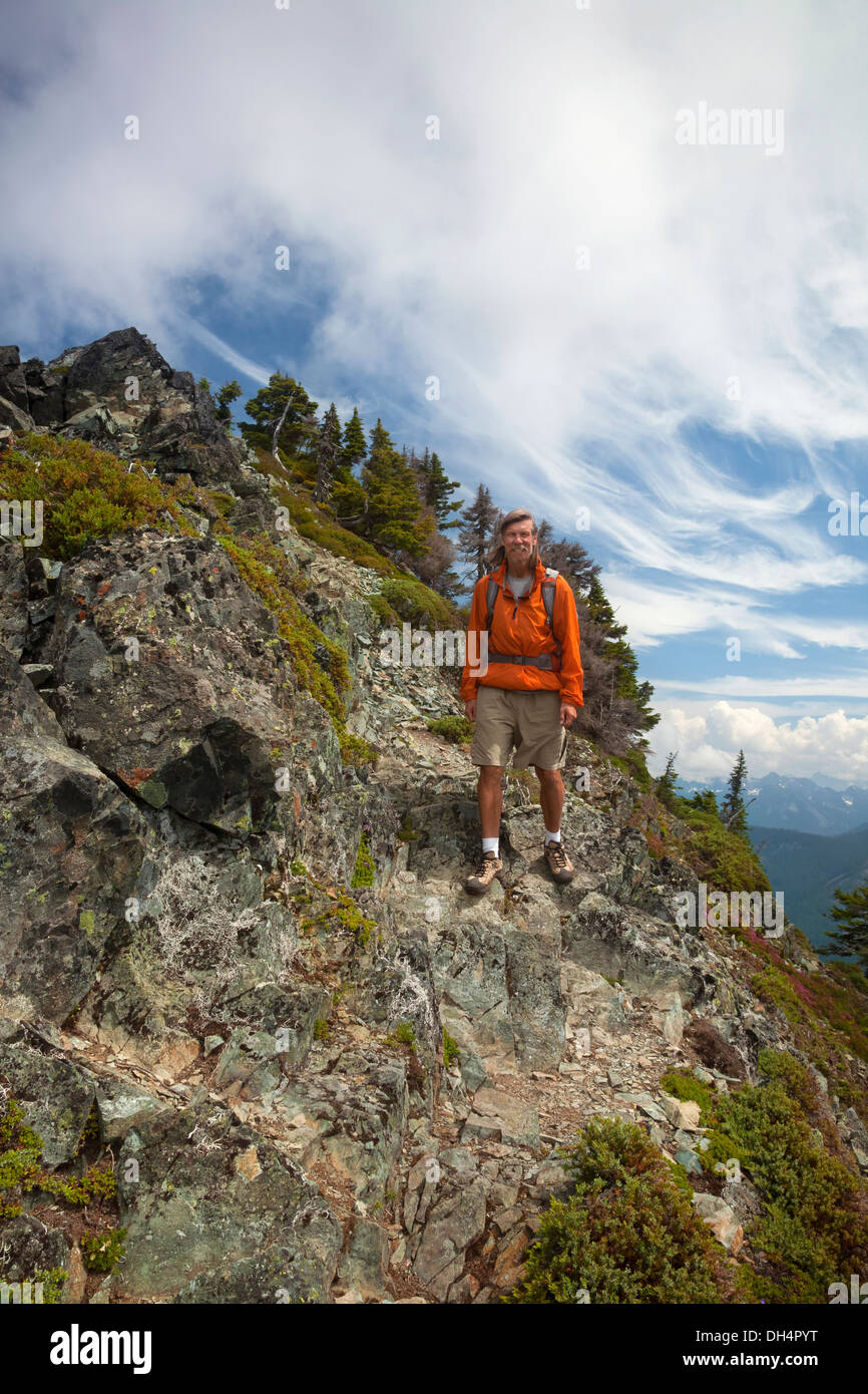 WASHINGTON - Hiker descending the trail off the rocky summit of ...