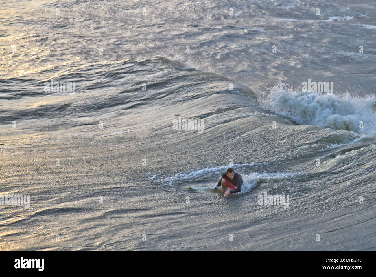 A surfer rides the backside of a huge wave from Hurricane Sandy on ...