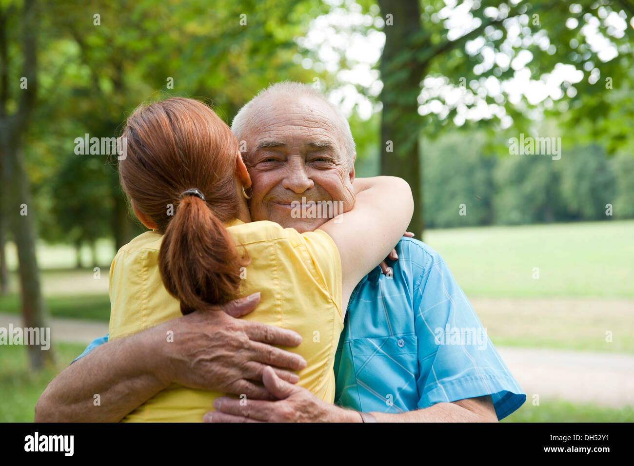Woman hugging an elderly man Stock Photo - Alamy