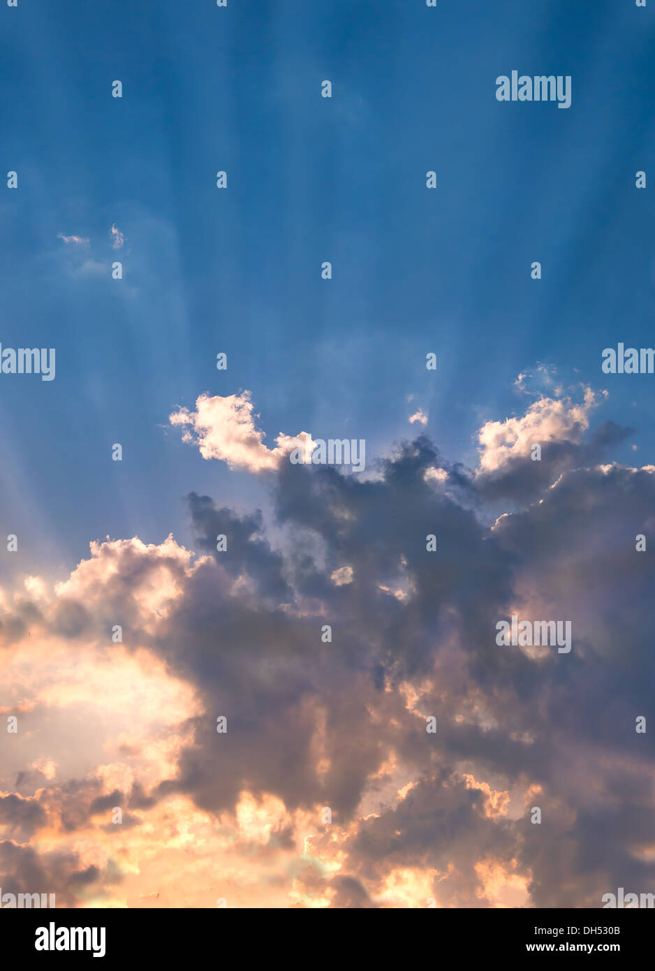 Suns rays beaming from behind clouds Stock Photo - Alamy